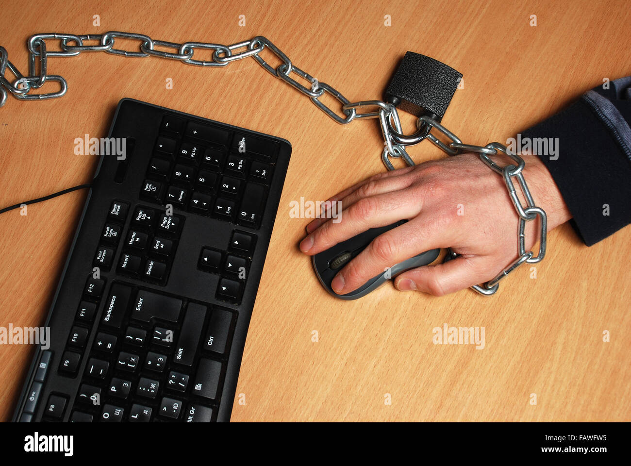 the man chained to the workplace, working at a computer Stock Photo - Alamy