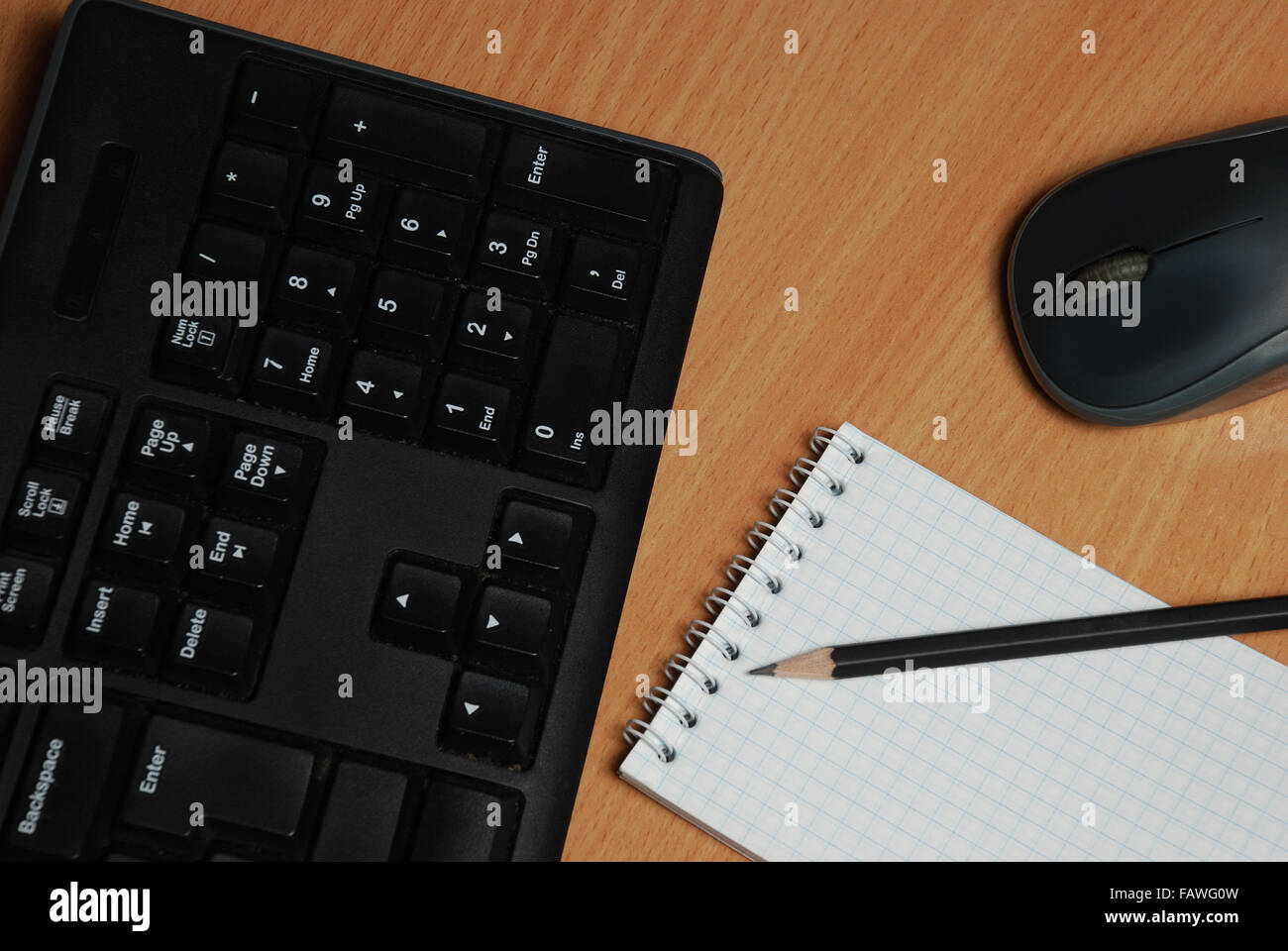 workstation with a keyboard, a notebook, a pencil and a computer mouse ...