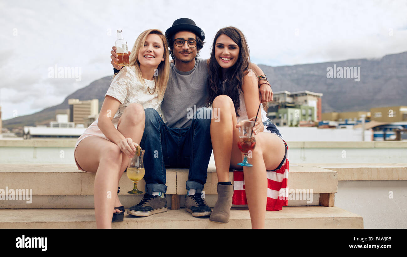 Portrait of best friends having a party on rooftop. Young man and women ...