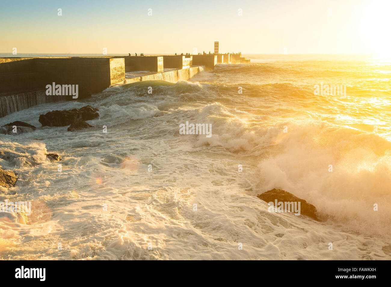Stone pier and surf waves at sunset Stock Photo - Alamy