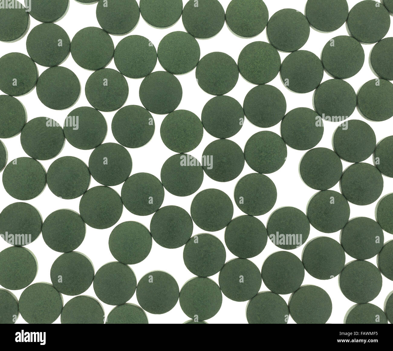 A layer of green iron supplement tablets isolated on a white background ...