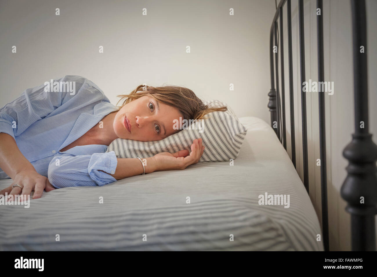 Young woman lying on her bed Stock Photo - Alamy