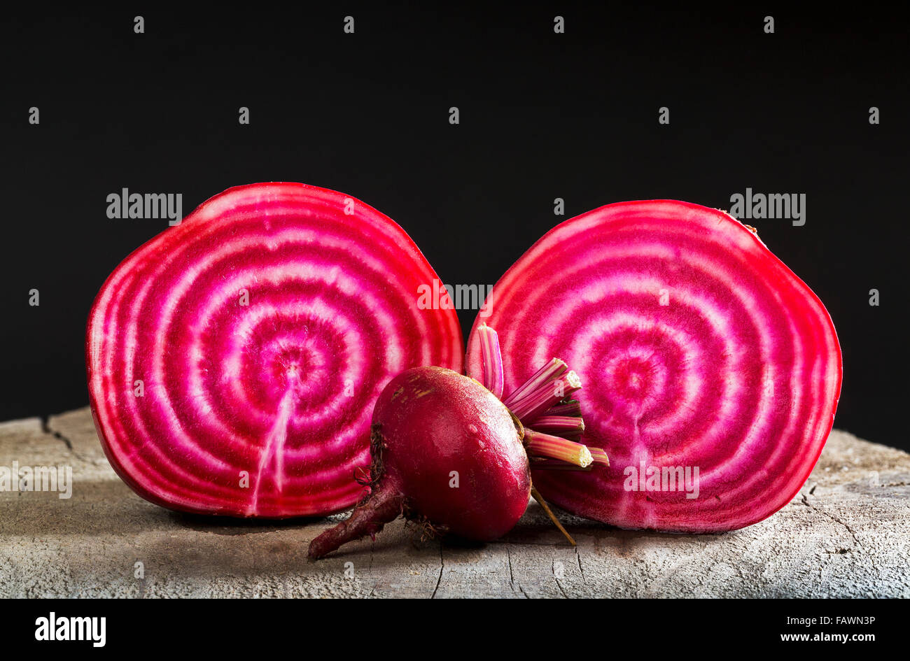 Close up of a cut red and white striped beet with an uncut small beet ...