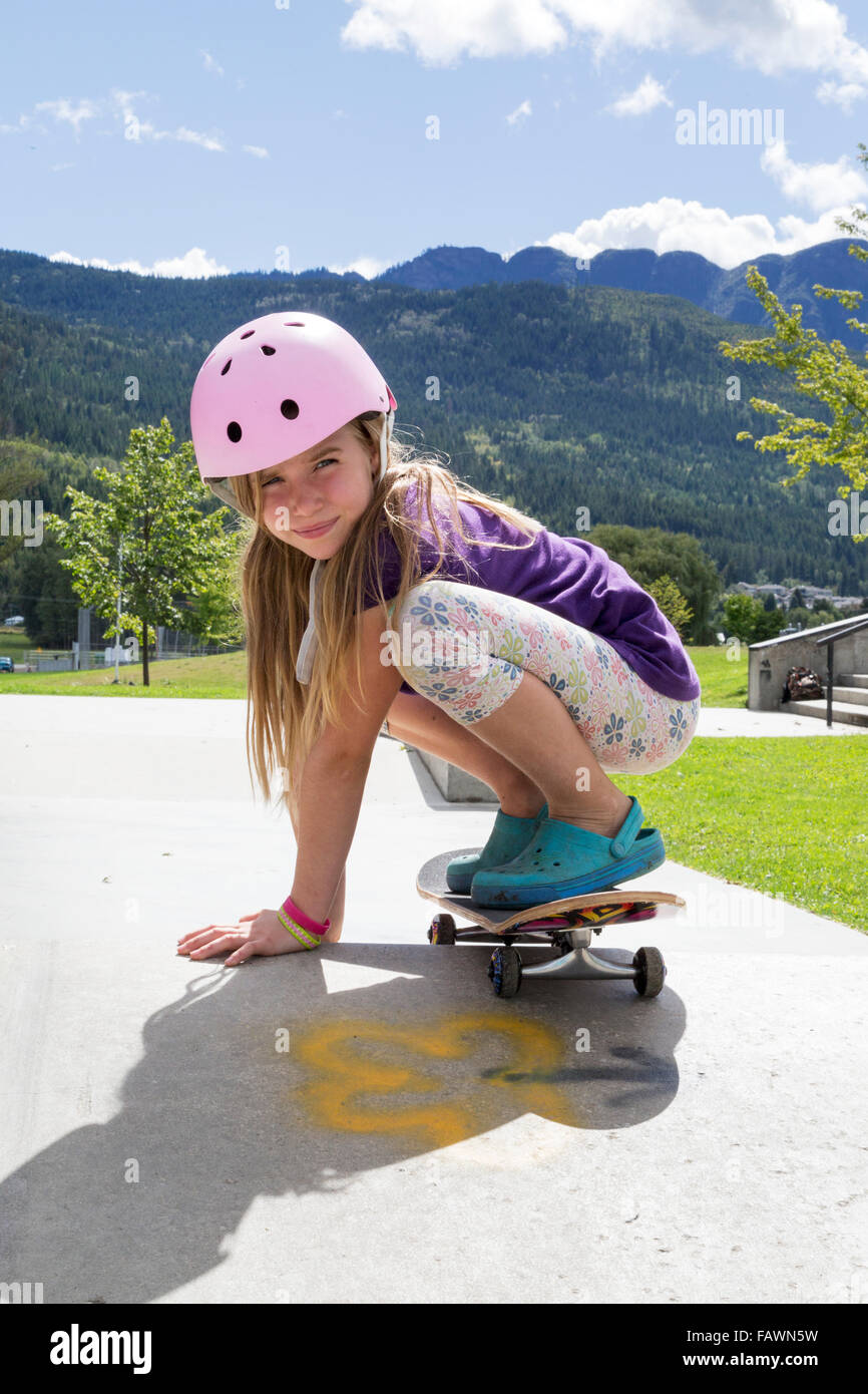 Young girl on a skateboard wearing a pink helmet; Salmon Arm, British ...