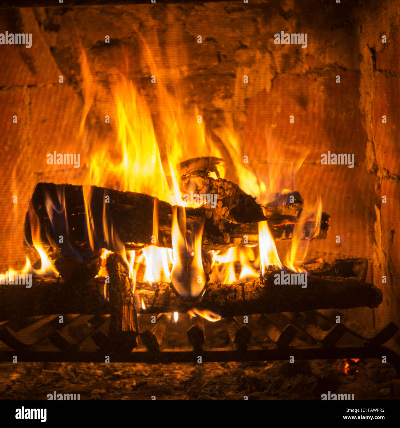Bright orange and yellow flames in a burning fire in a fireplace; San ...