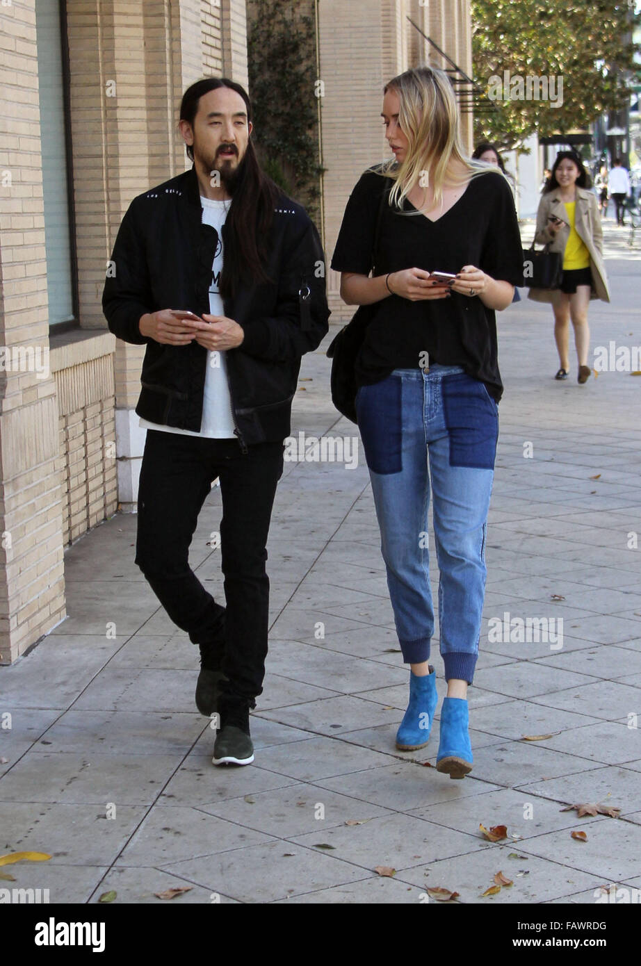 Musician Steve Aoki hold hands with his fiancee Tiernan Cowling as they ...