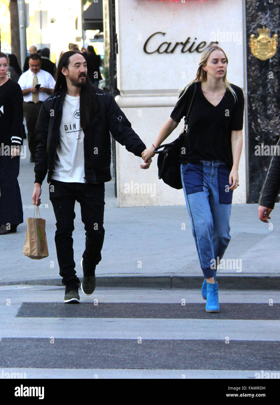 Musician Steve Aoki hold hands with his fiancee Tiernan Cowling as they ...