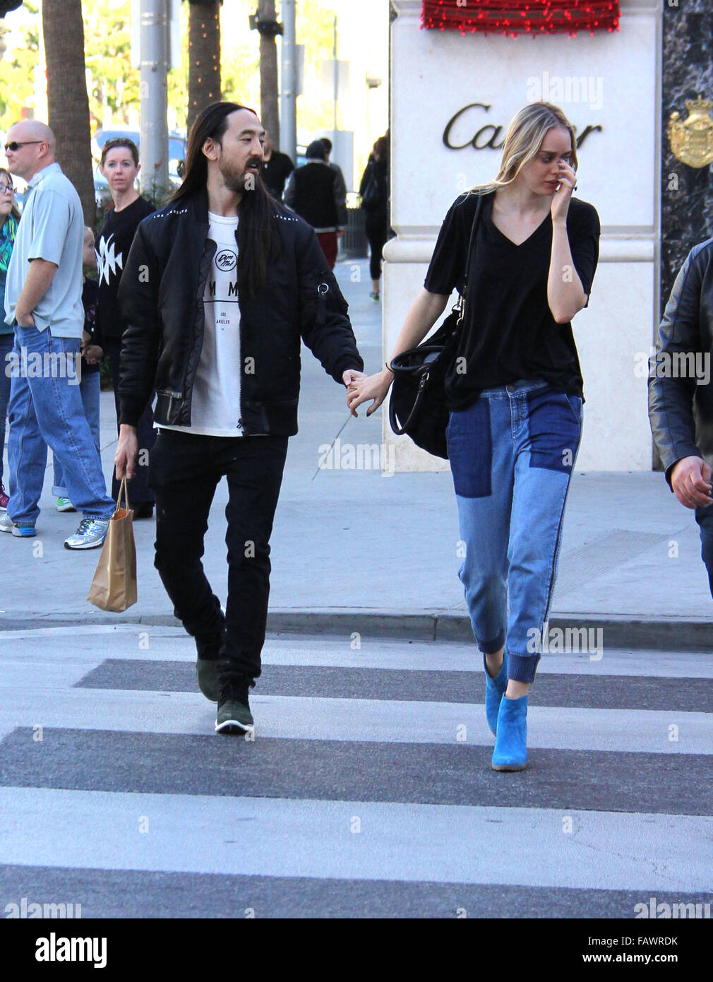 Musician Steve Aoki hold hands with his fiancee Tiernan Cowling as they ...