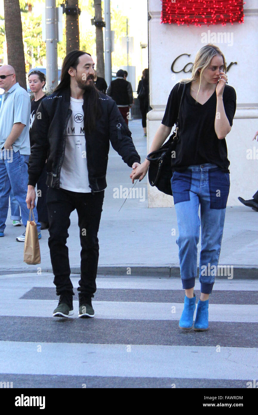 Musician Steve Aoki hold hands with his fiancee Tiernan Cowling as they ...