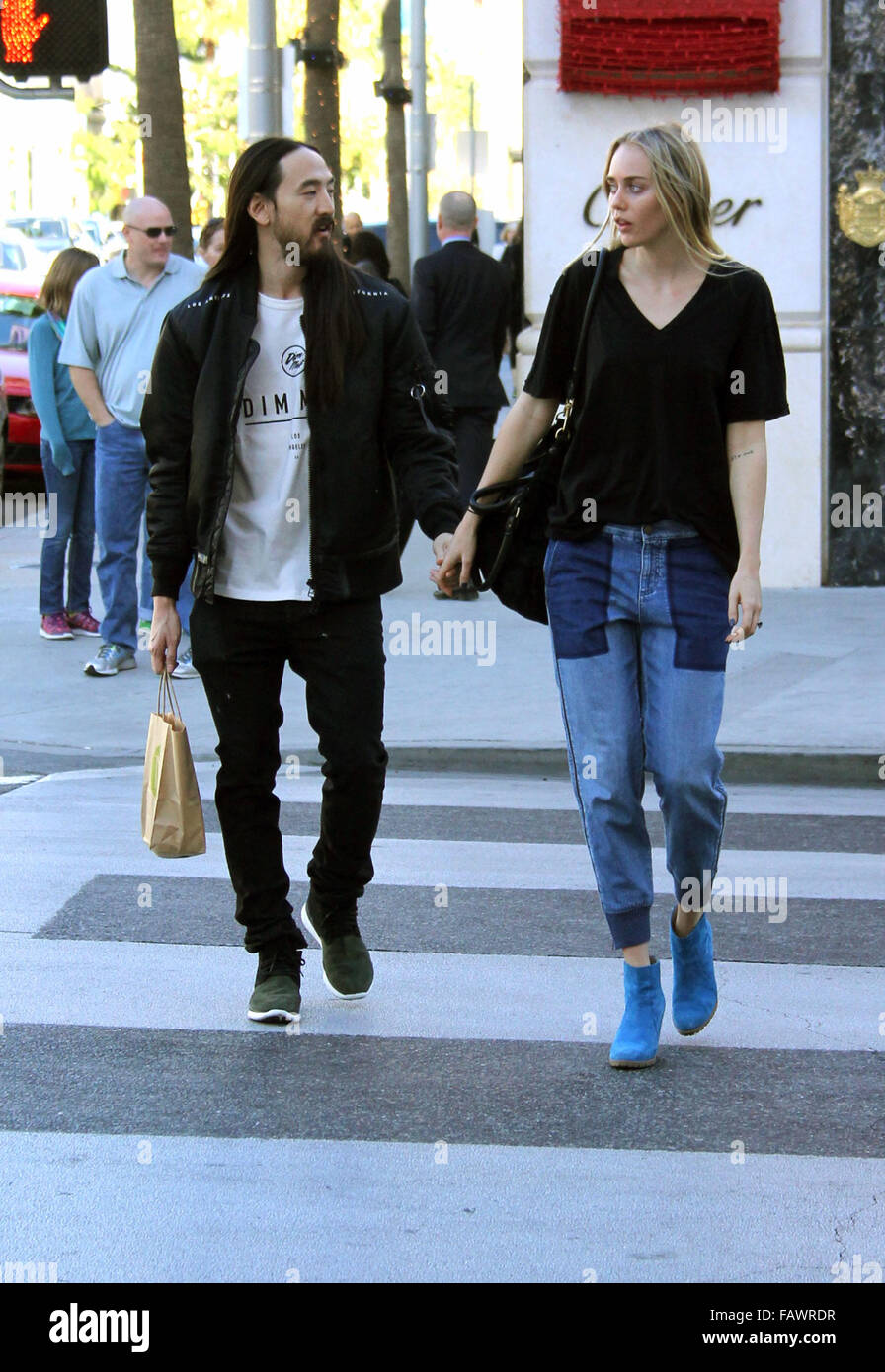 Musician Steve Aoki hold hands with his fiancee Tiernan Cowling as they ...