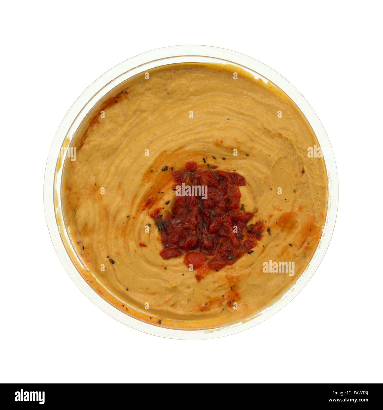Top view of hummus with red peppers in a translucent plastic container ...