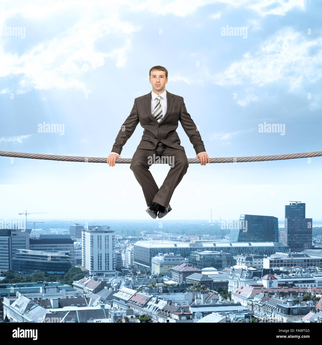 Businessman sitting on rope Stock Photo - Alamy