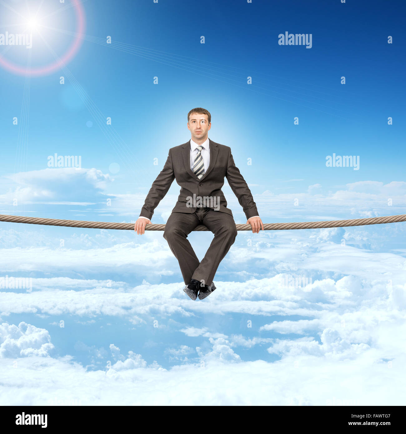 Businessman sitting on rope Stock Photo - Alamy
