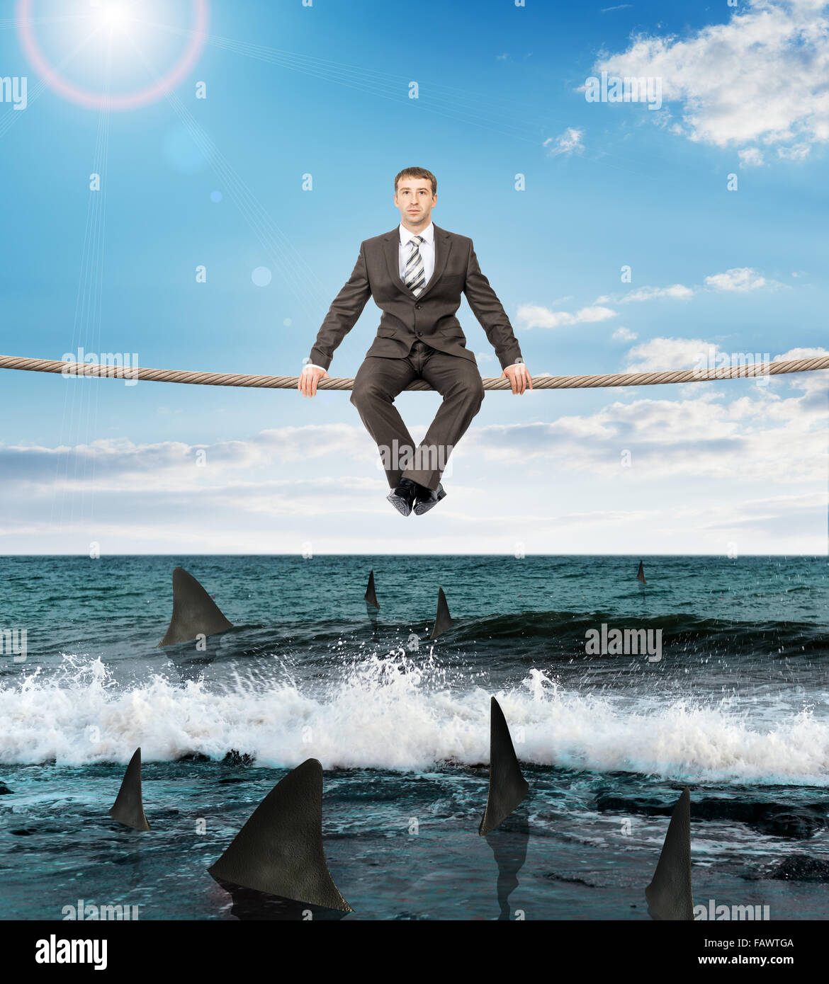 Businessman sitting on rope Stock Photo - Alamy