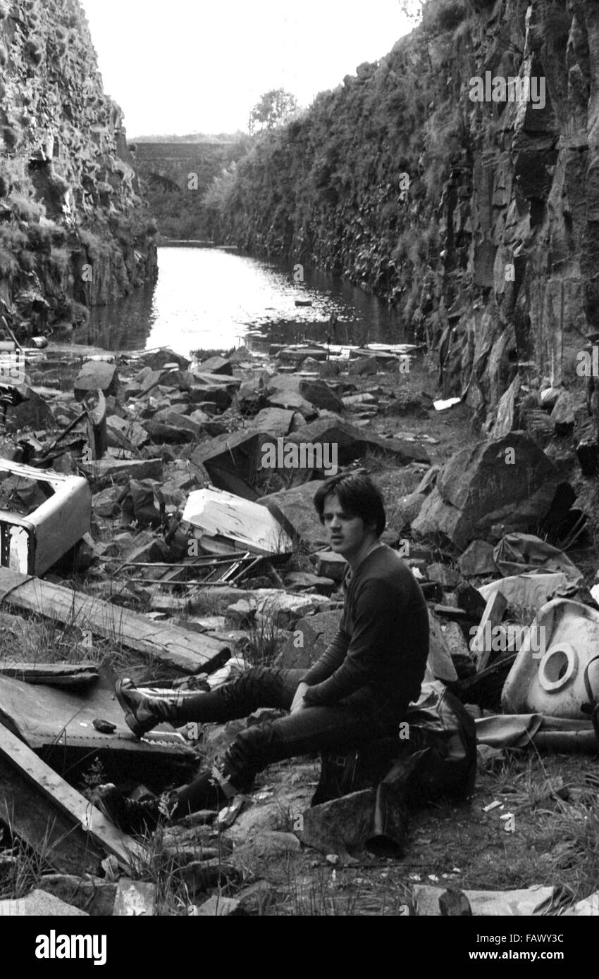 Young man sitting on rubble in the flooded Strines cutting on the ...
