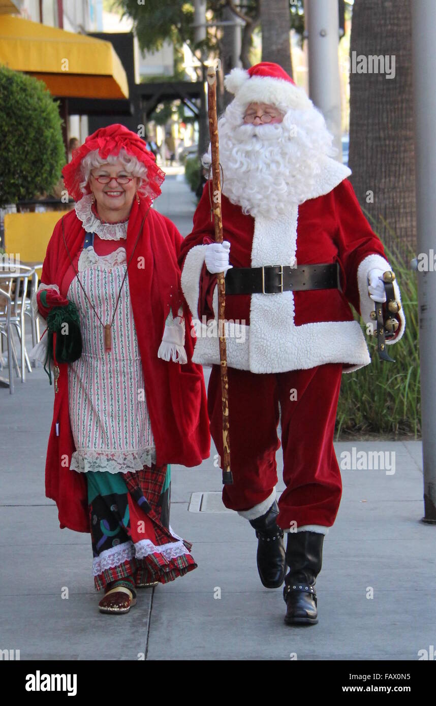 A couple dressed up as Santa Claus and Mrs Claus taking a walk together ...