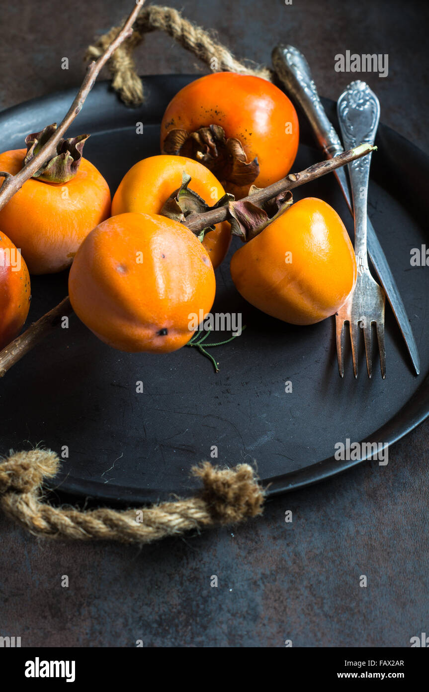 Ripe persimmons fruits on rustic background Stock Photo - Alamy