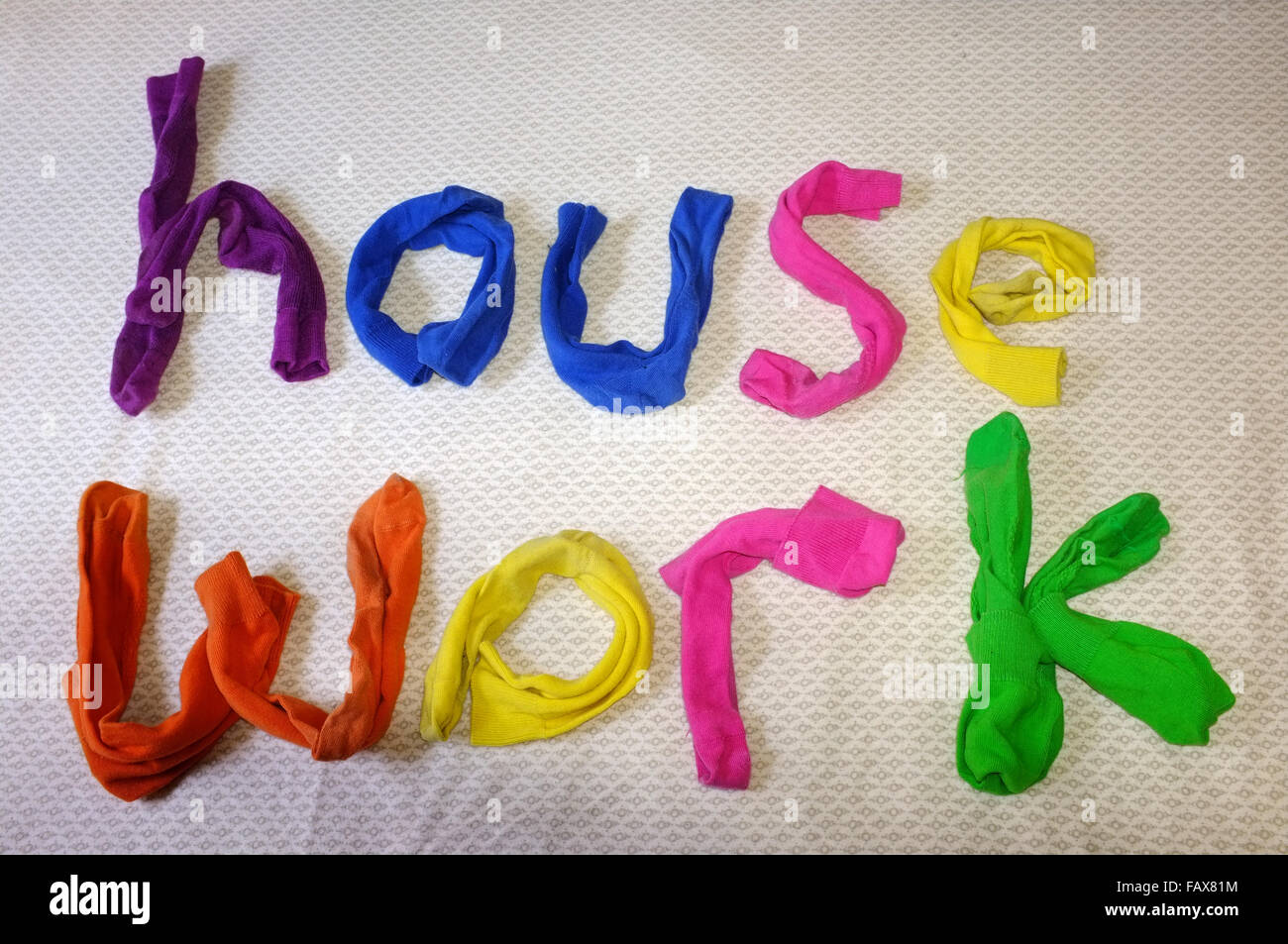The words house work made out of colourful socks laying on a duvet ...