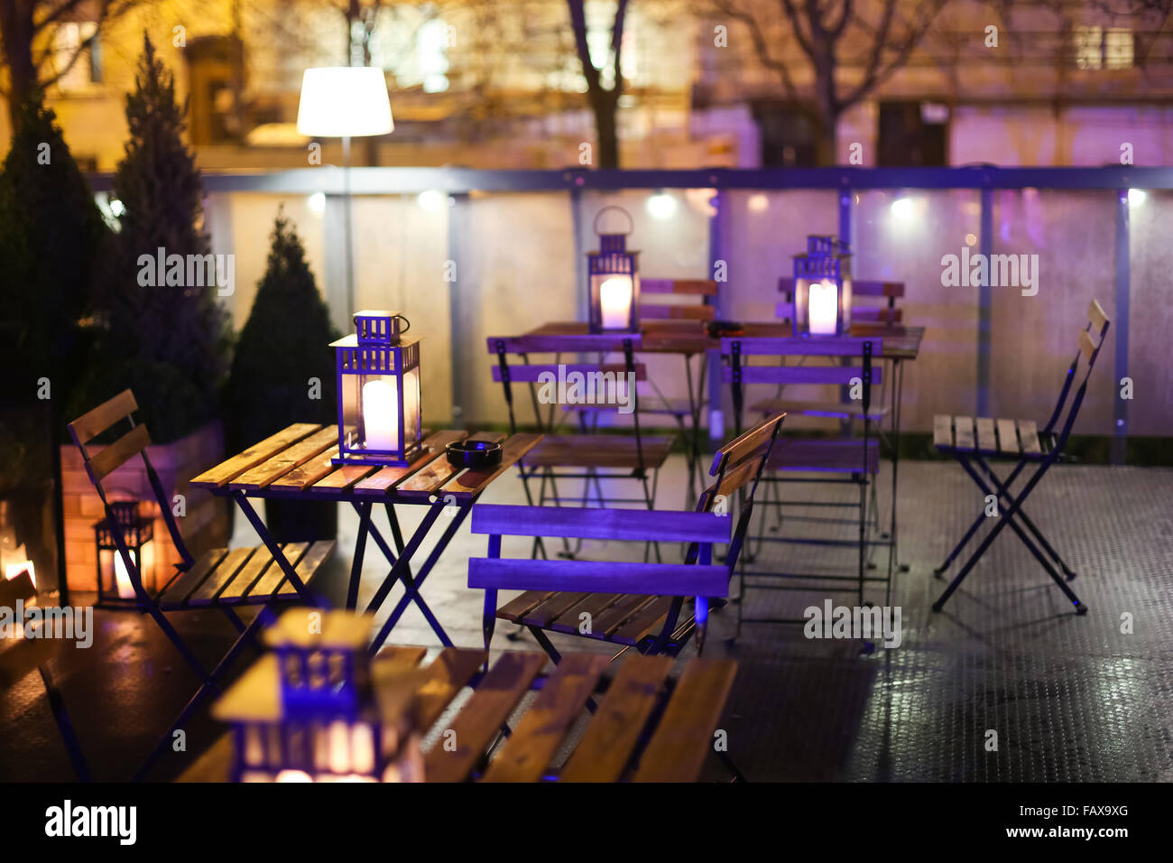 A view of the illuminated coffee tables on the terrace at night in ...