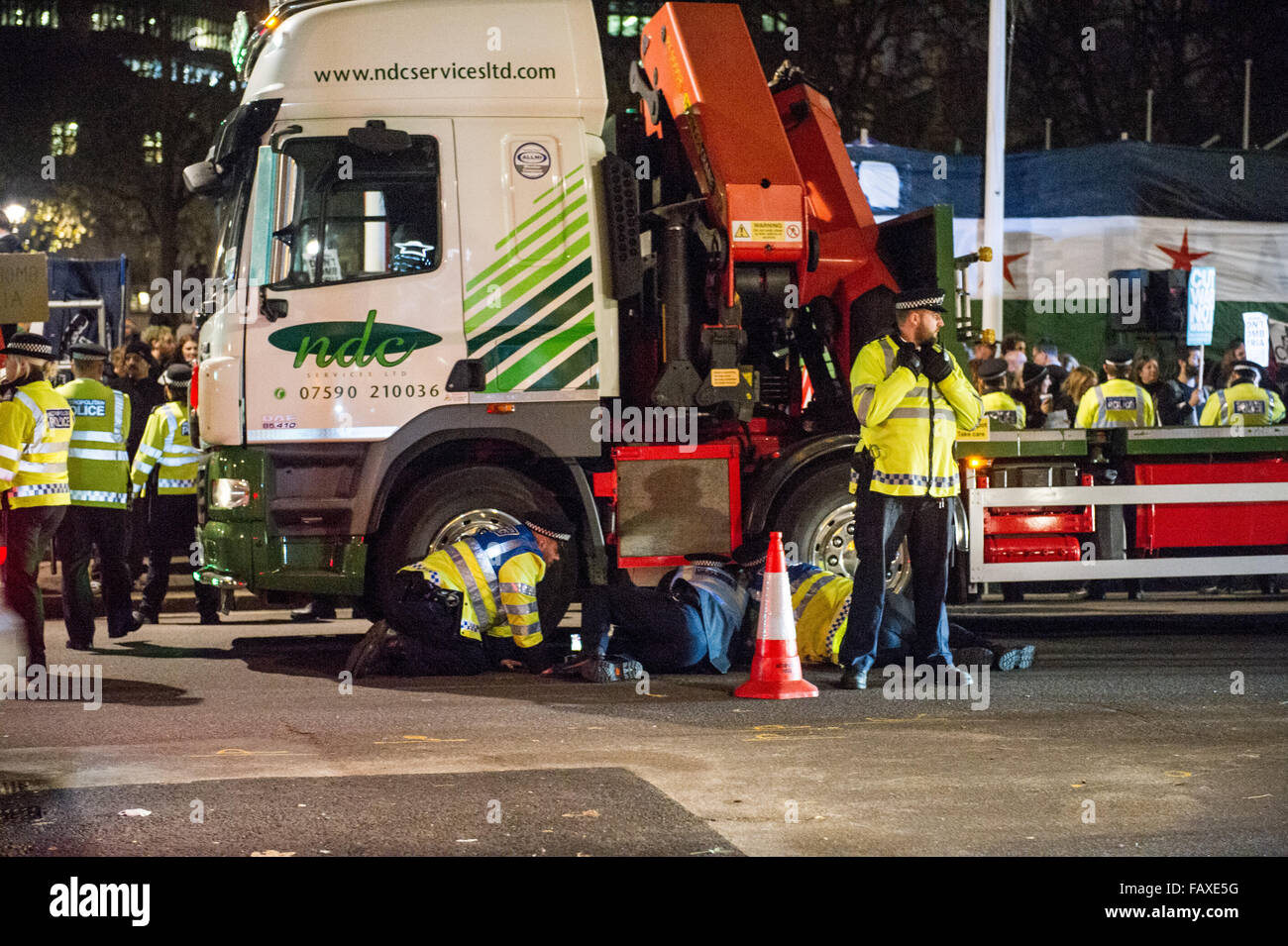 A female anti-war protester 'locks-on' under a lorry blocking traffic ...