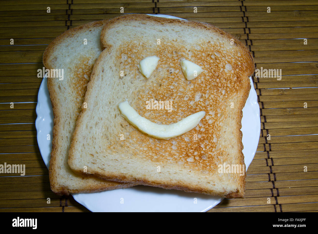Toast on white plate with butter eyes and smile Stock Photo - Alamy