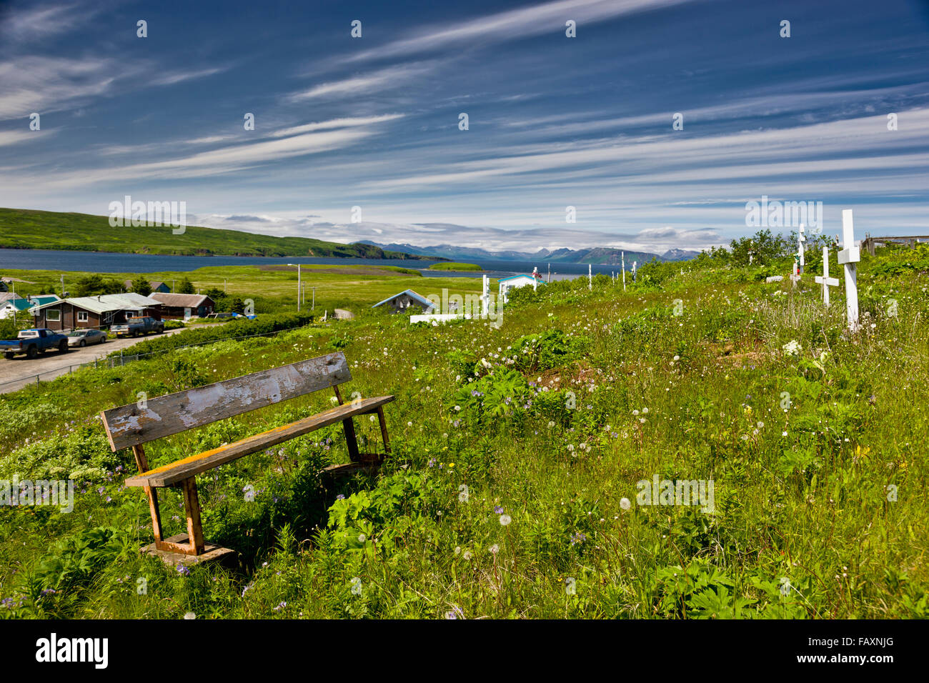 An old weathered bench sits among grave markers in the Sand Point ...