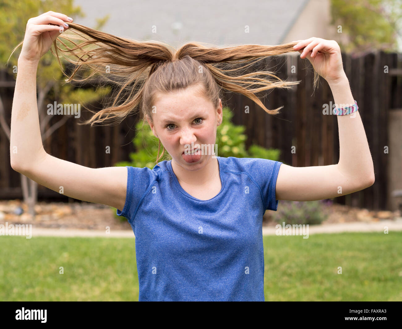 Teenager holding up messy hair in playful frustration Stock Photo - Alamy