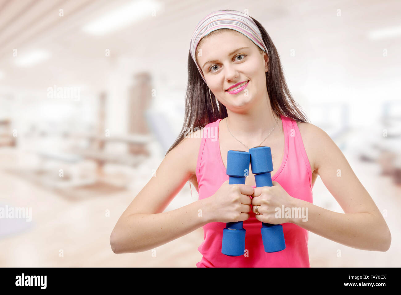 a portrait of pretty sporty girl holding weights Stock Photo - Alamy