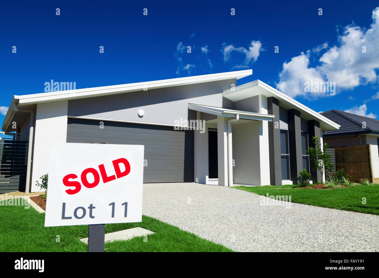 New suburban Australian house with a large SOLD sign Stock Photo - Alamy