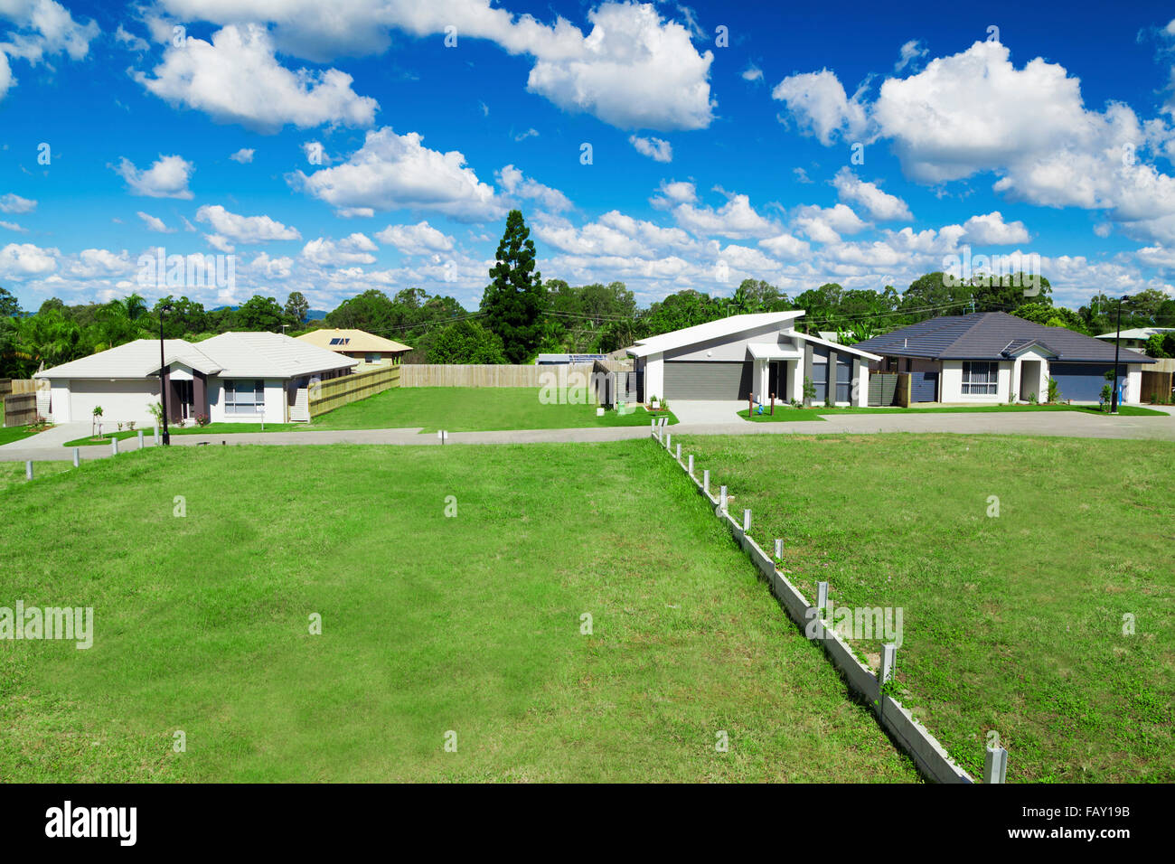 Sunny, green Australian housing development land with three newly built ...