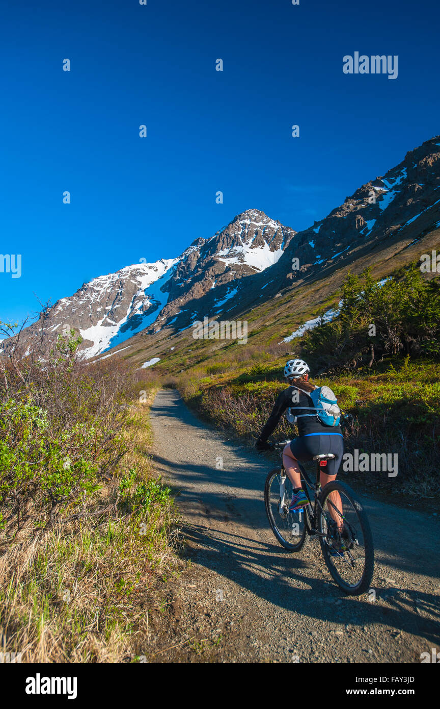 A woman riding her bike at Powerline Pass Valley in Chugach State Park ...