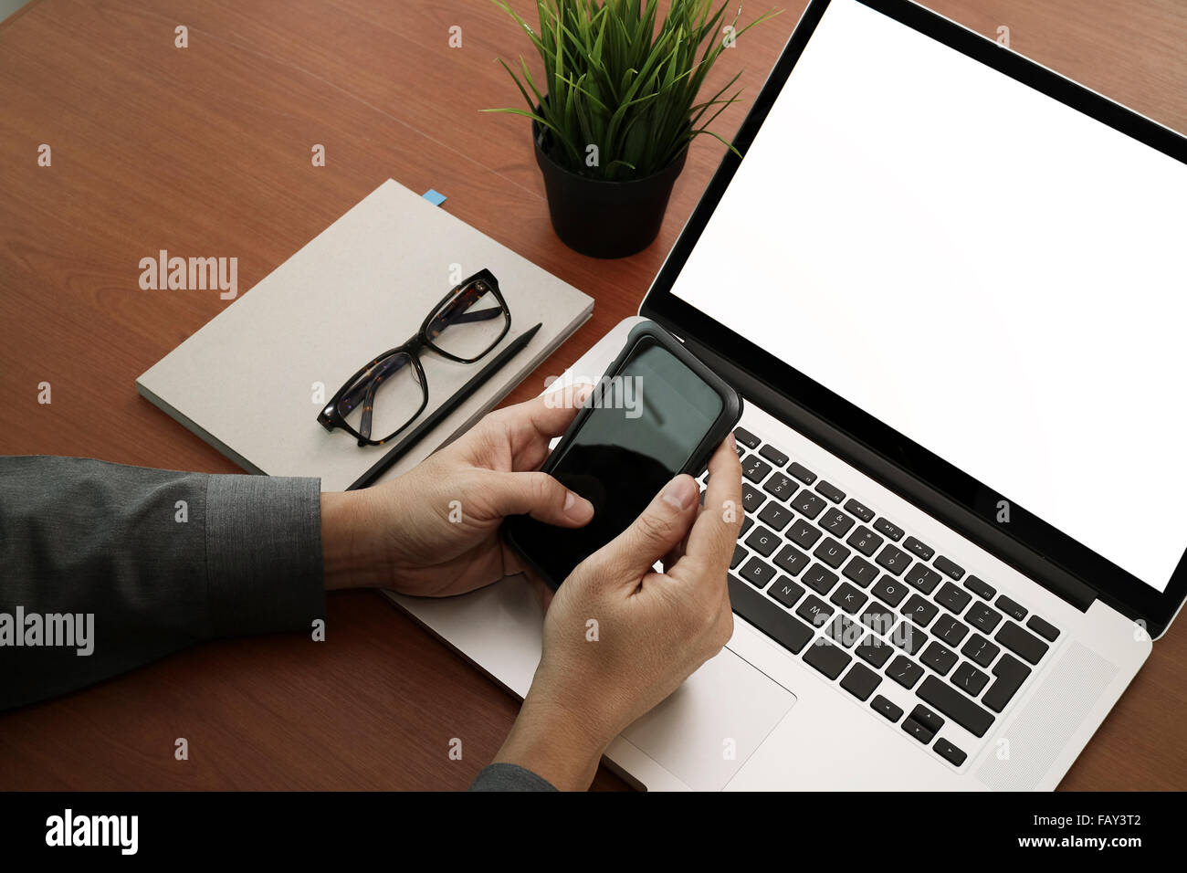 top view of businessman hand using on smart phone and laptop computer ...