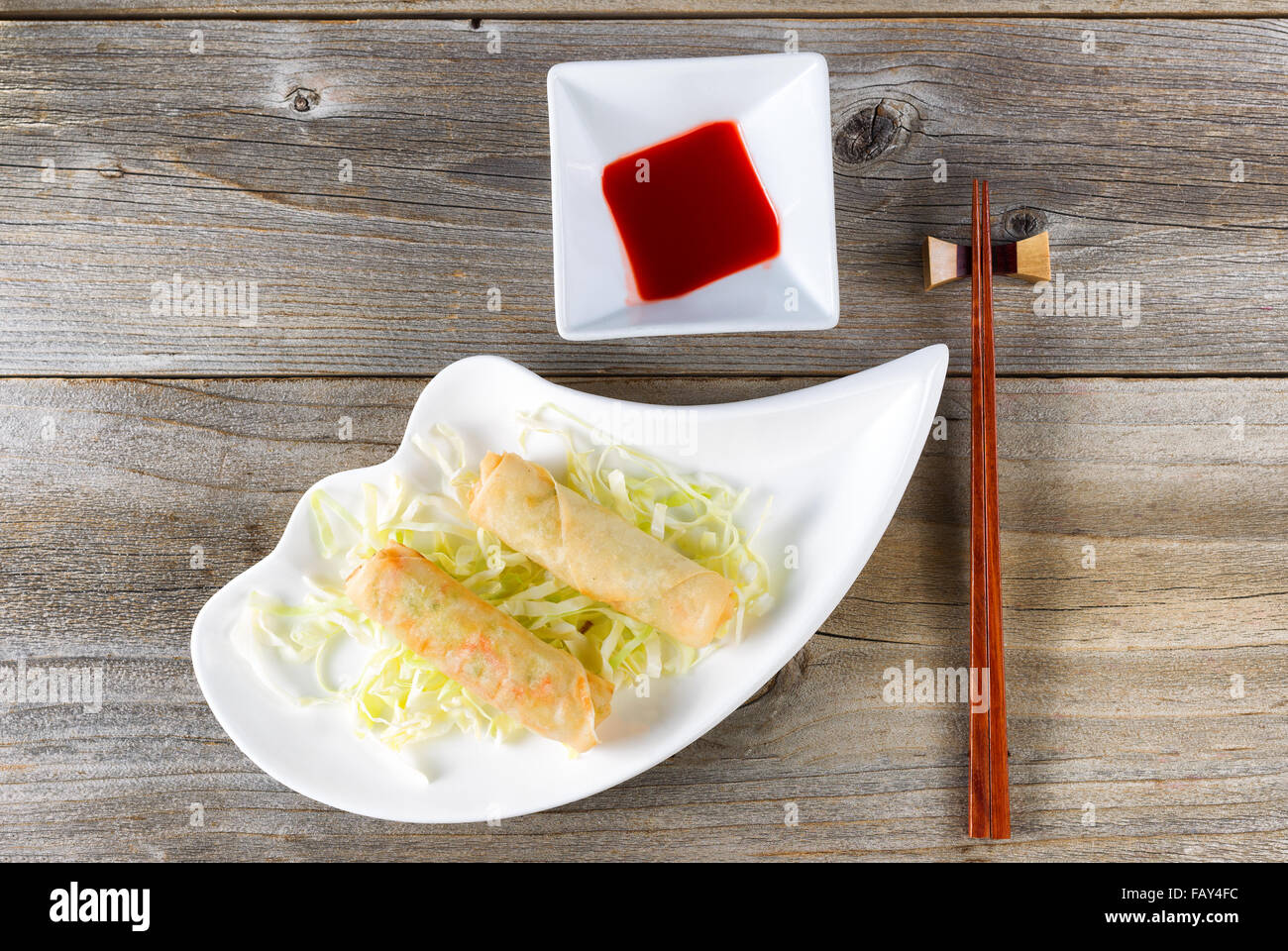 Top view of crispy spring rolls with dipping sauce and chopsticks in ...