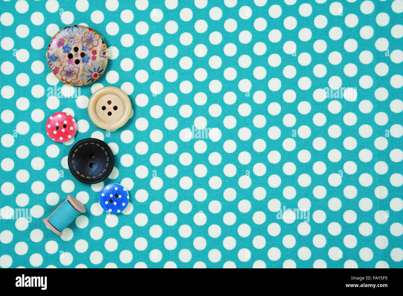 Buttons on blue polka dot fabric background Stock Photo - Alamy