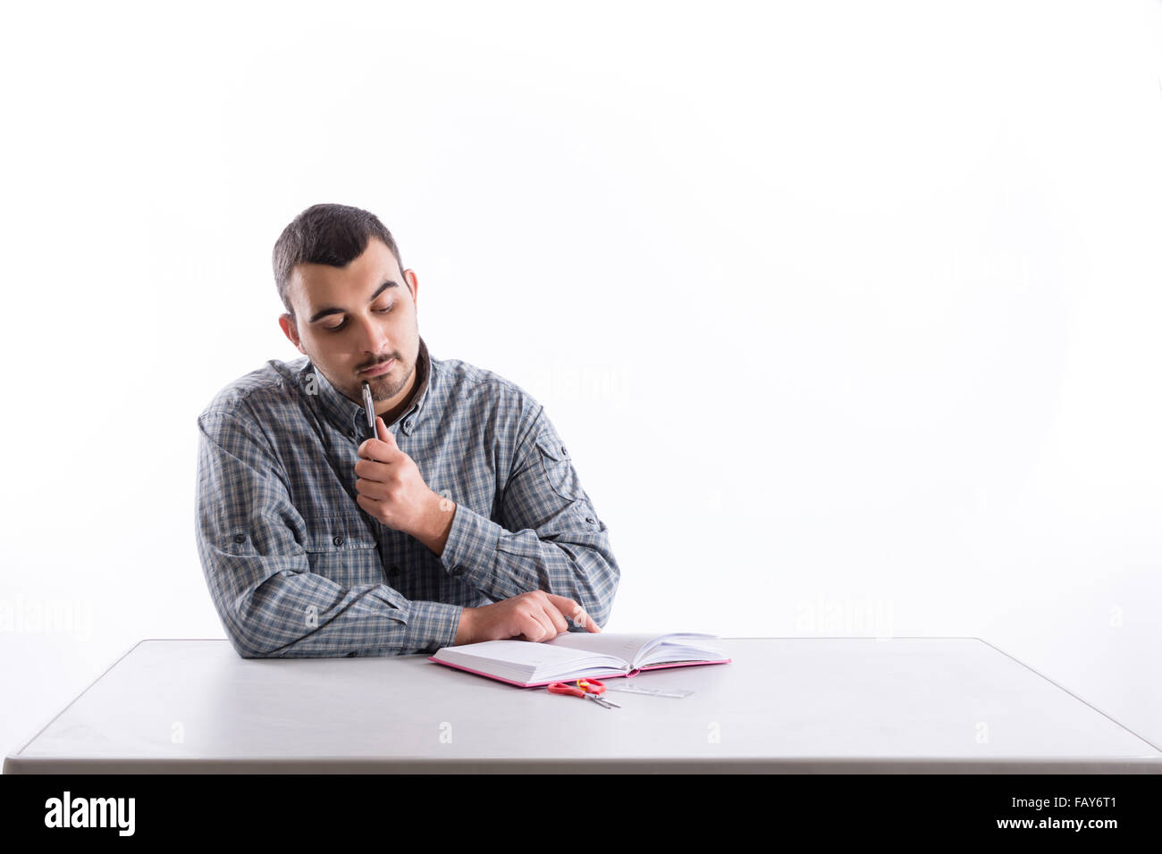 Thoughtful college student looking notebook exam Stock Photo - Alamy
