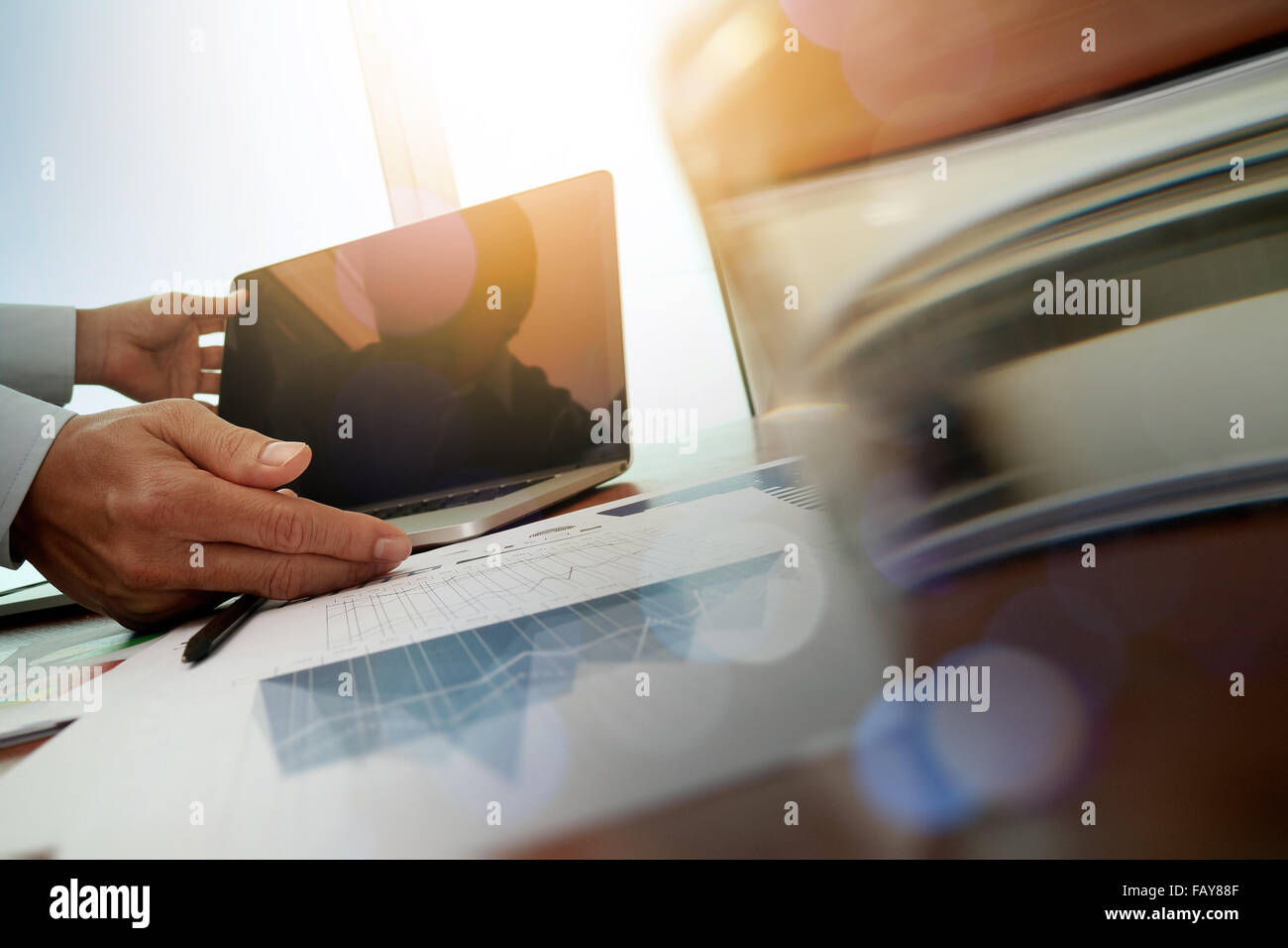 business man hand working on laptop computer with business graph ...