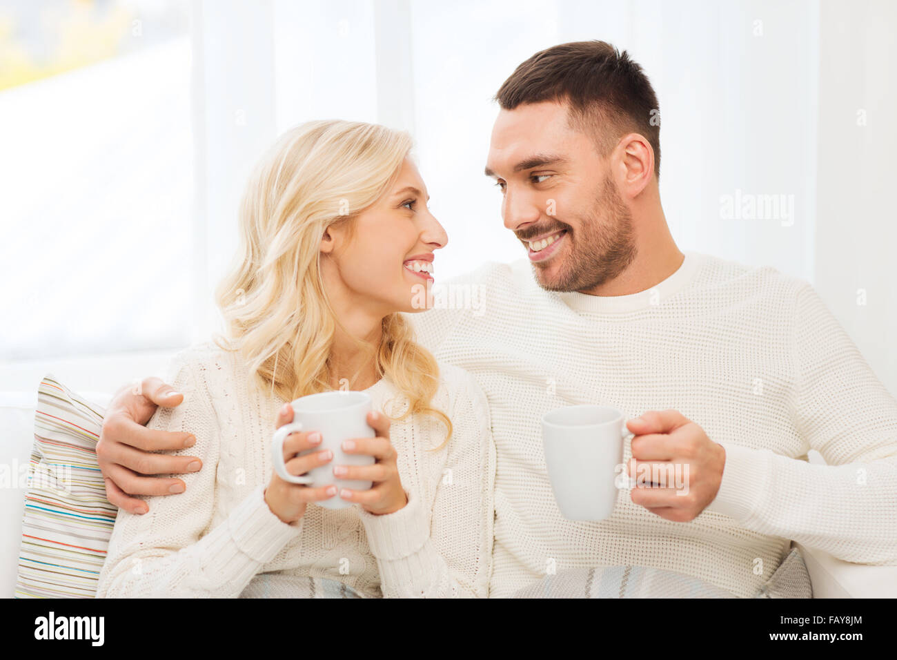 happy couple with cups drinking tea at home Stock Photo - Alamy