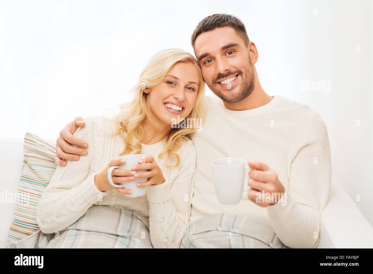 happy couple with cups drinking tea at home Stock Photo - Alamy