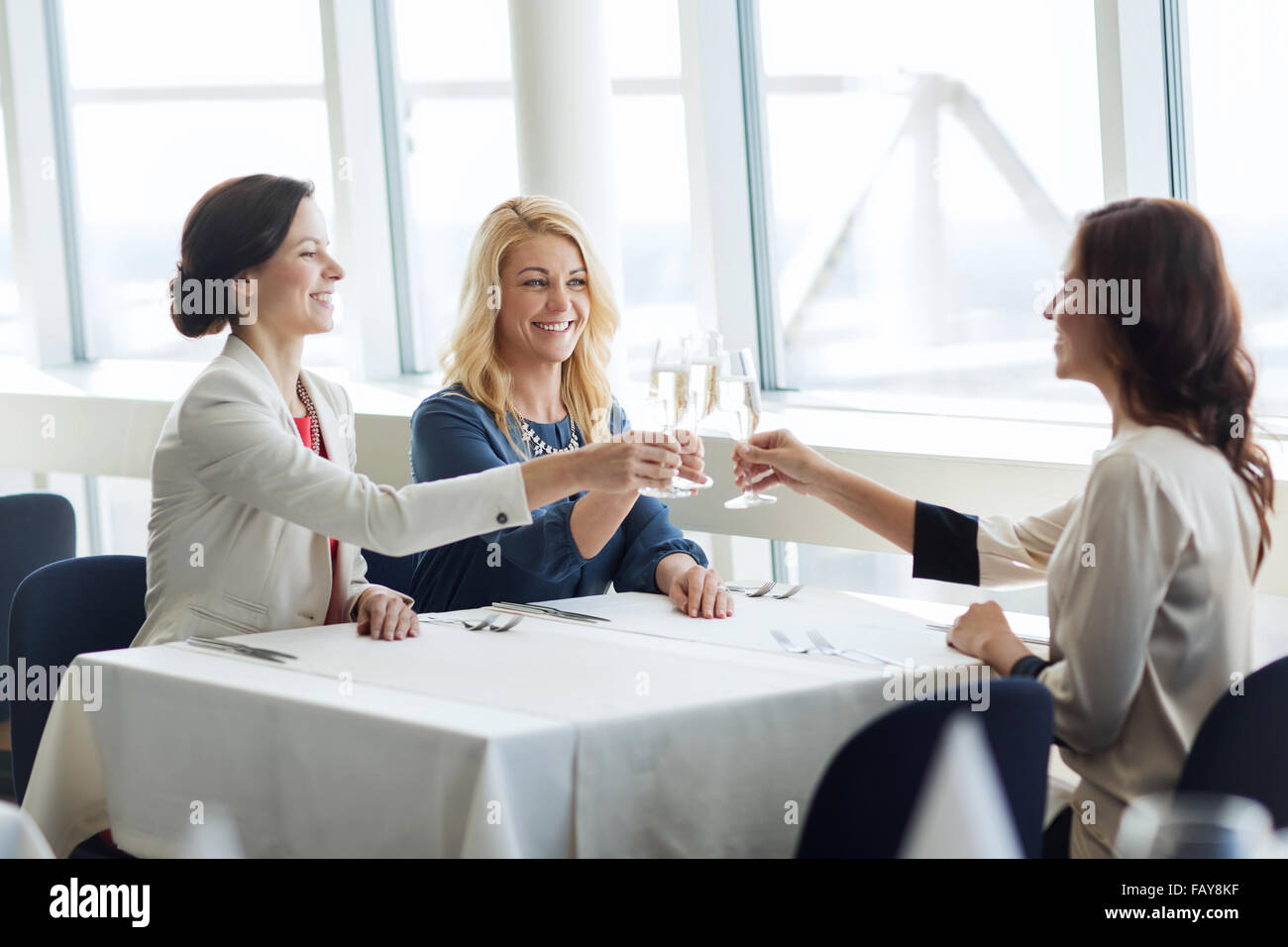 happy women drinking champagne at restaurant Stock Photo - Alamy