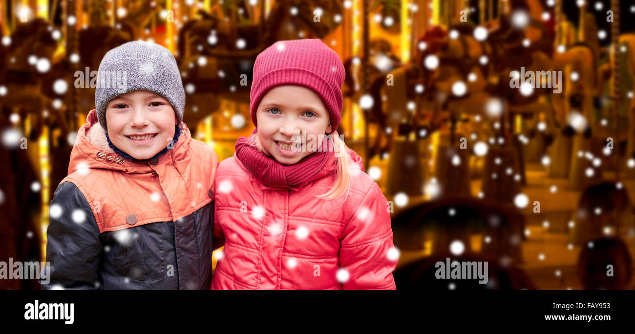 little girl hugging boy over snow and carousel Stock Photo - Alamy