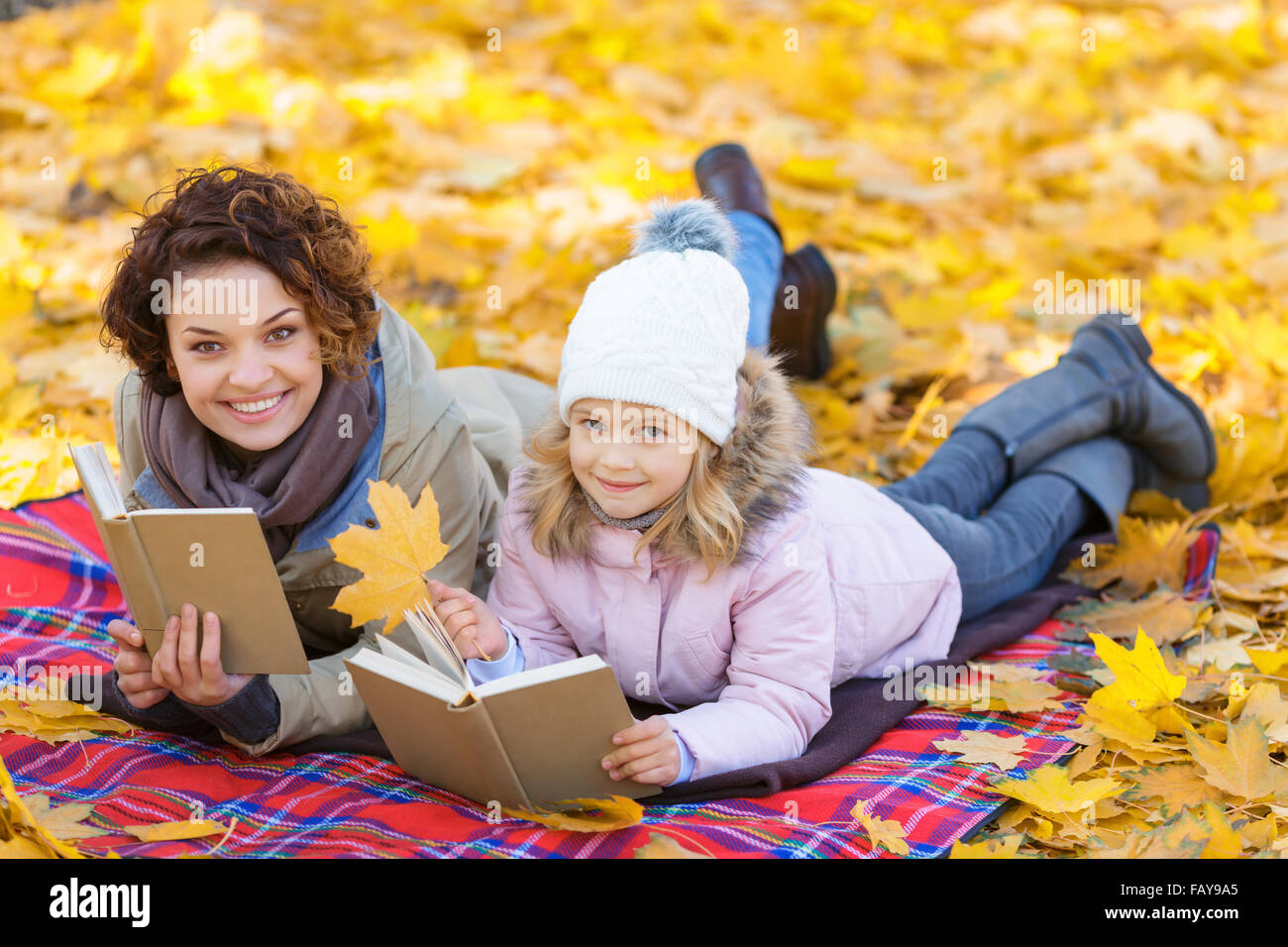Positive mother and daughter reading books Stock Photo - Alamy