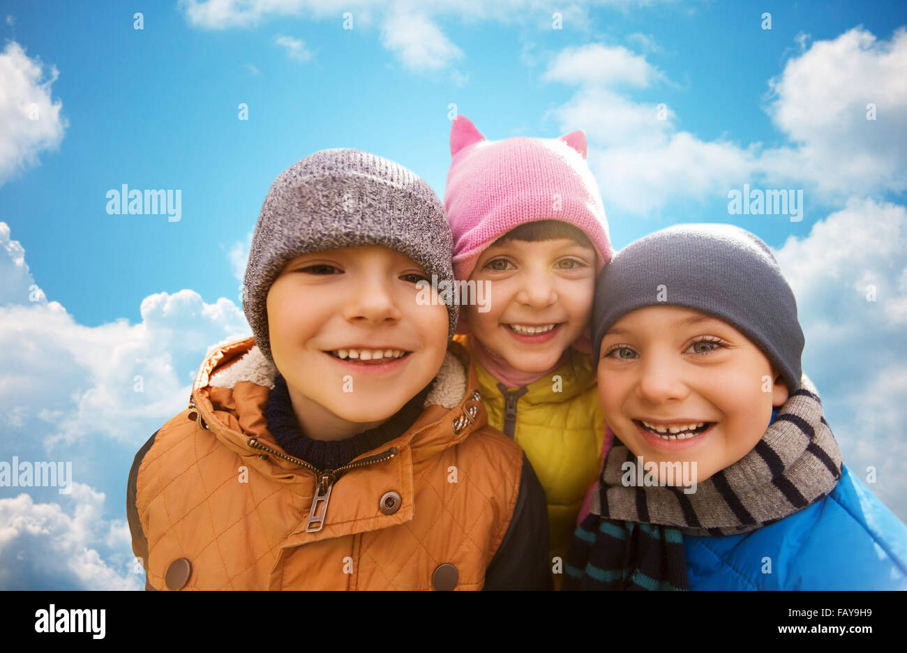 happy children hugging over blue sky background Stock Photo - Alamy