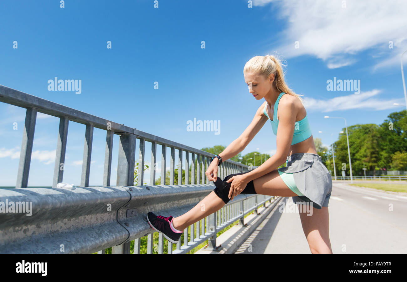 young woman with injured knee or leg outdoors Stock Photo - Alamy