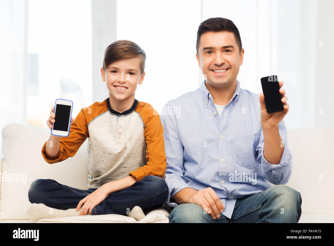 happy father and son with smartphones at home Stock Photo - Alamy