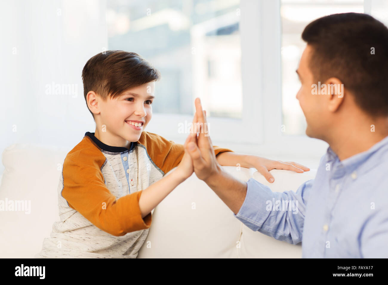 happy father and son doing high five at home Stock Photo - Alamy
