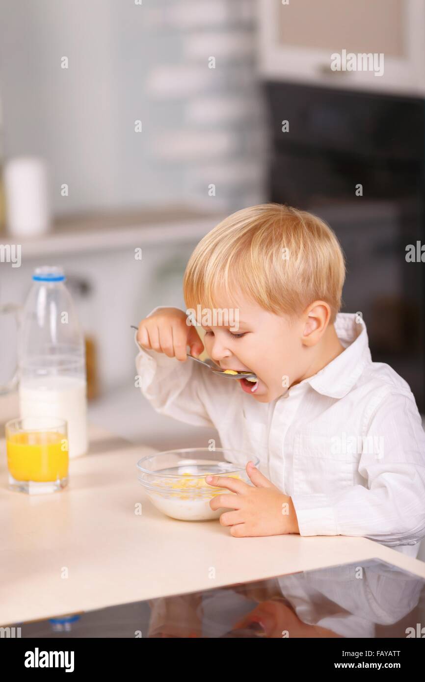 Small boy eats cornflakes with lots of appetite Stock Photo - Alamy