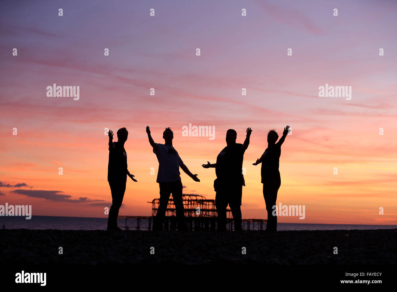 Four singers pictured on Brighton Beach with the West Pier in the ...