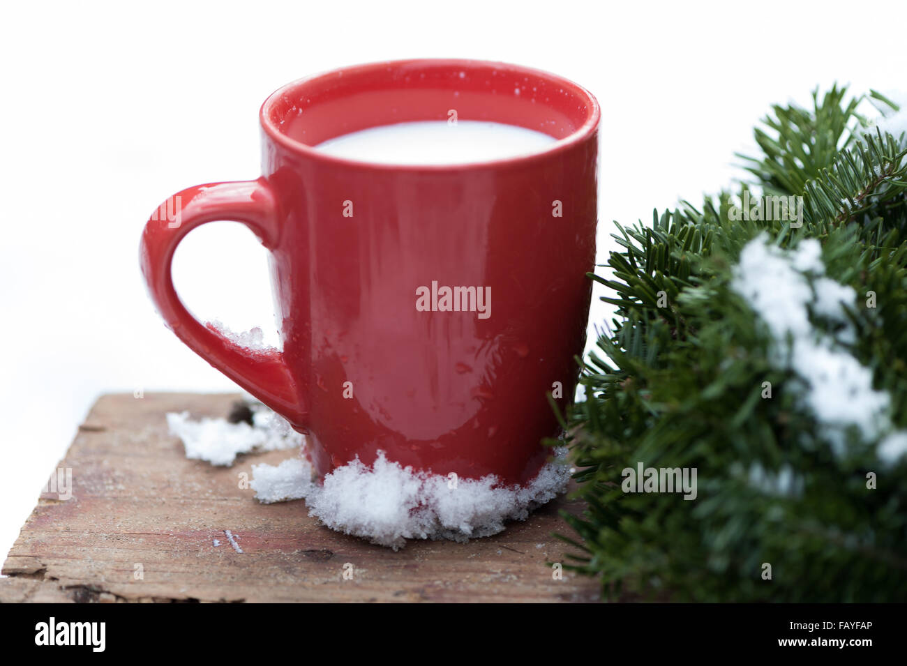Warm milk in a cup in the snow Stock Photo - Alamy