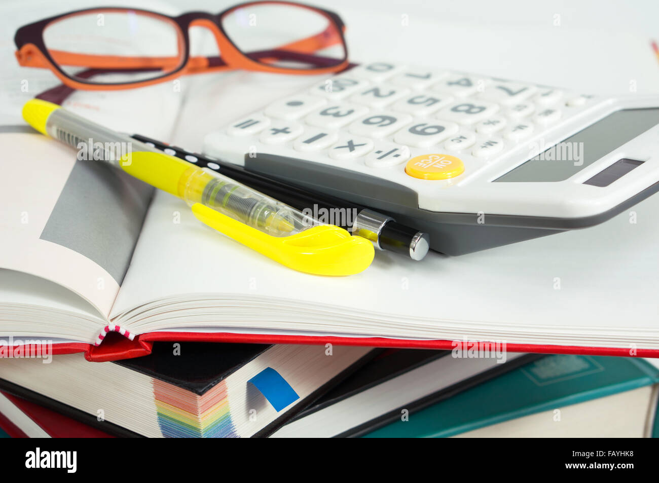 Pen and calculator on books with eyeglasses for financial and ...