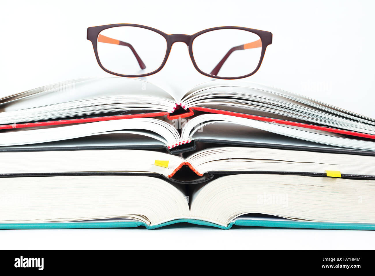Eyeglasses on stack of open books Stock Photo - Alamy